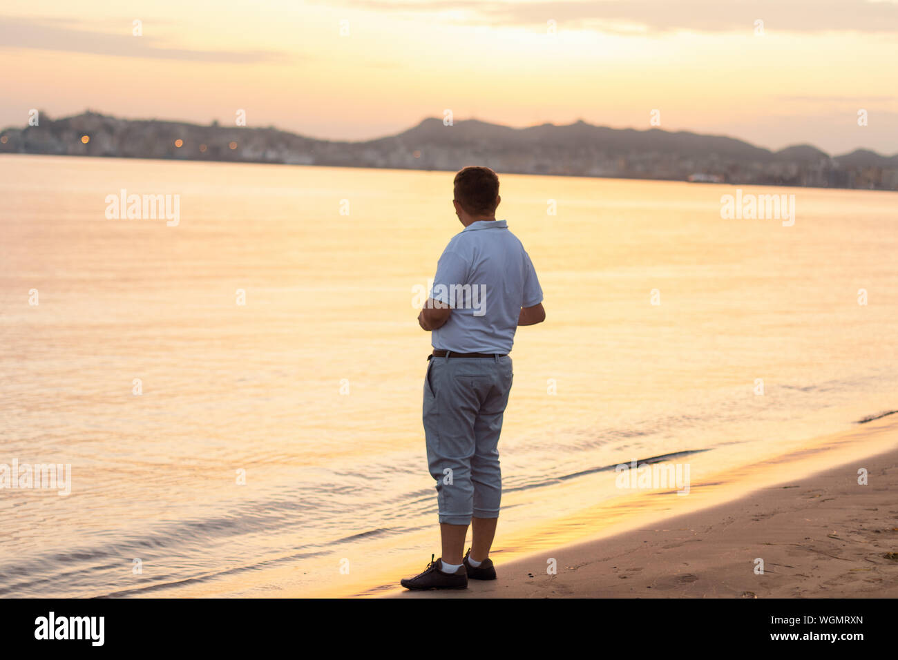 back of thinking man who watching the sunset over the ocean Stock Photo ...