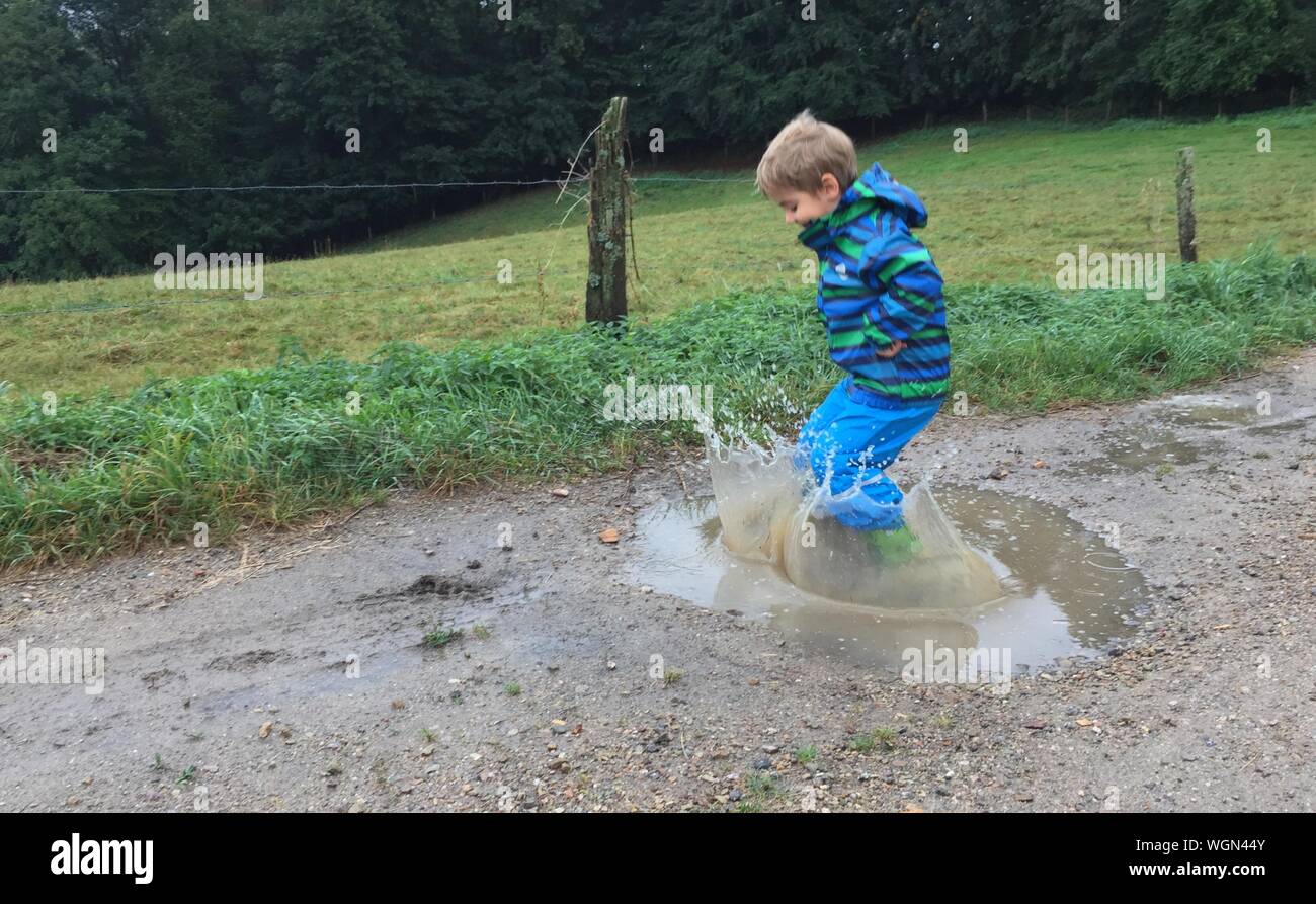Boy puddle splashing hi-res stock photography and images - Alamy
