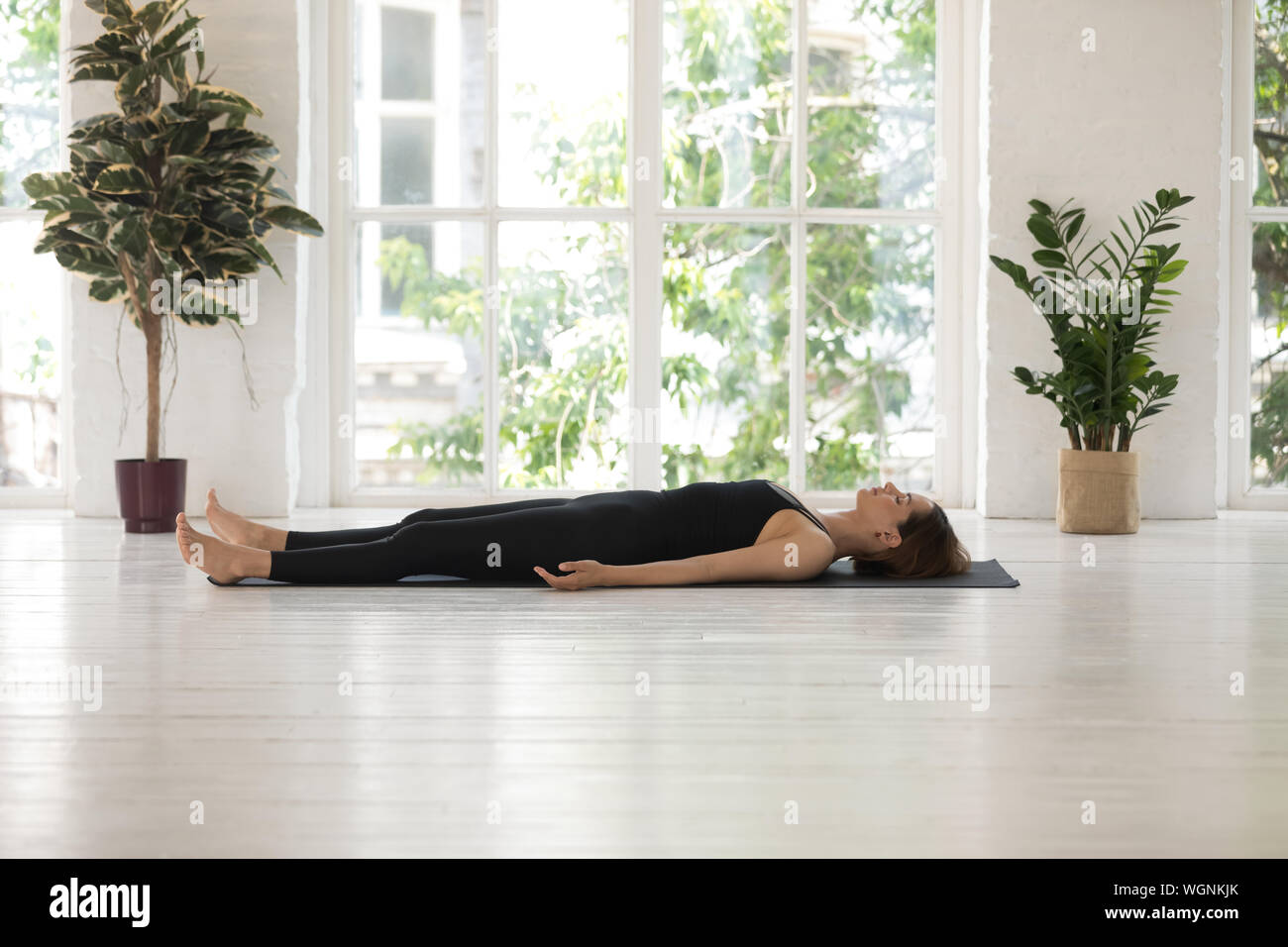 Young woman doing Savasana exercise, Dead Body, Corpse, practicing yoga ...