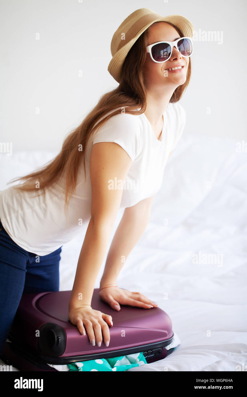 Beautiful woman is packing clothing in suitcase at home Stock Photo - Alamy