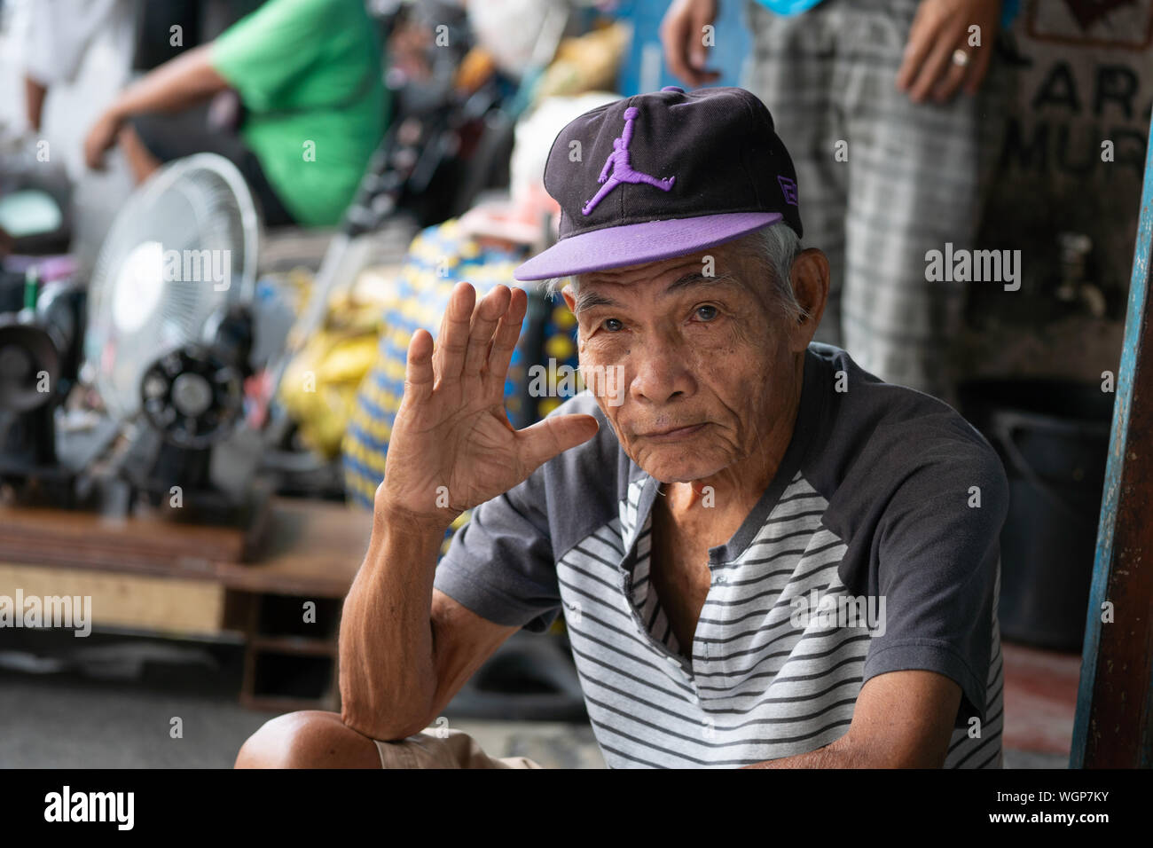 A Filipino man poses for a portrait on a sidewalk within Cebu City ...