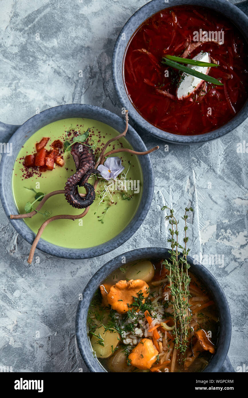 Gray plates with different soups on a gray background. Plate with ...