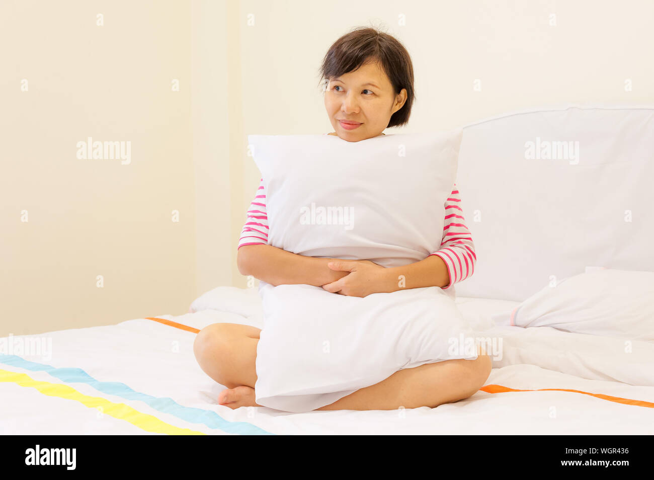 Woman Sitting On Bed Stock Photo - Alamy