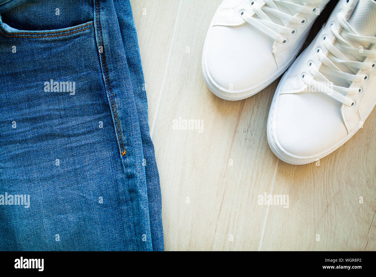 Pair of new stylish white sneakers on wood floor Stock Photo - Alamy