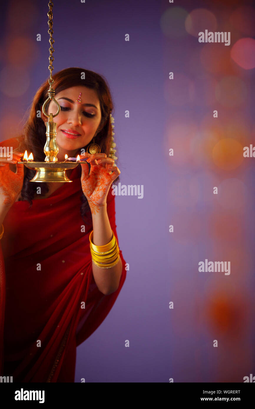 Women lighting diya hi-res stock photography and images - Alamy