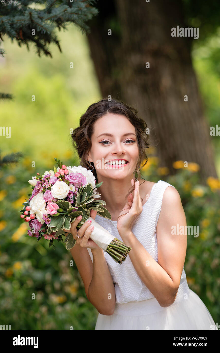 Emotional portrait of a happy bride in fashion wedding dress on natural ...