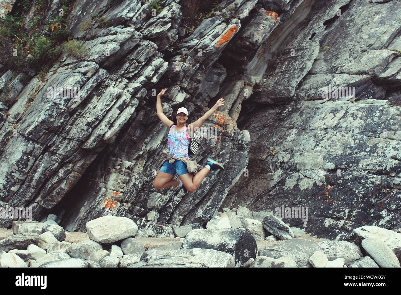 Woman jumping rock formation hi-res stock photography and images - Alamy