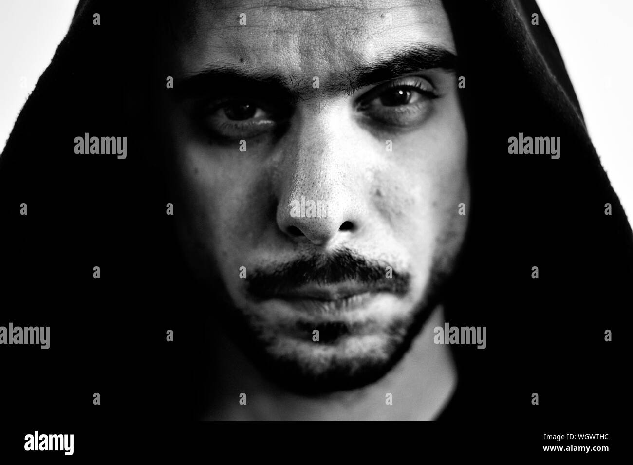 Portrait Of Young Bearded Man Wearing Hood Against White Background ...