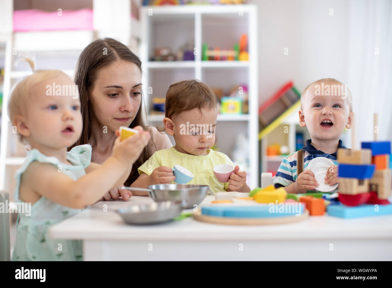Nursery babies playing with teacher in the classroom Stock Photo - Alamy