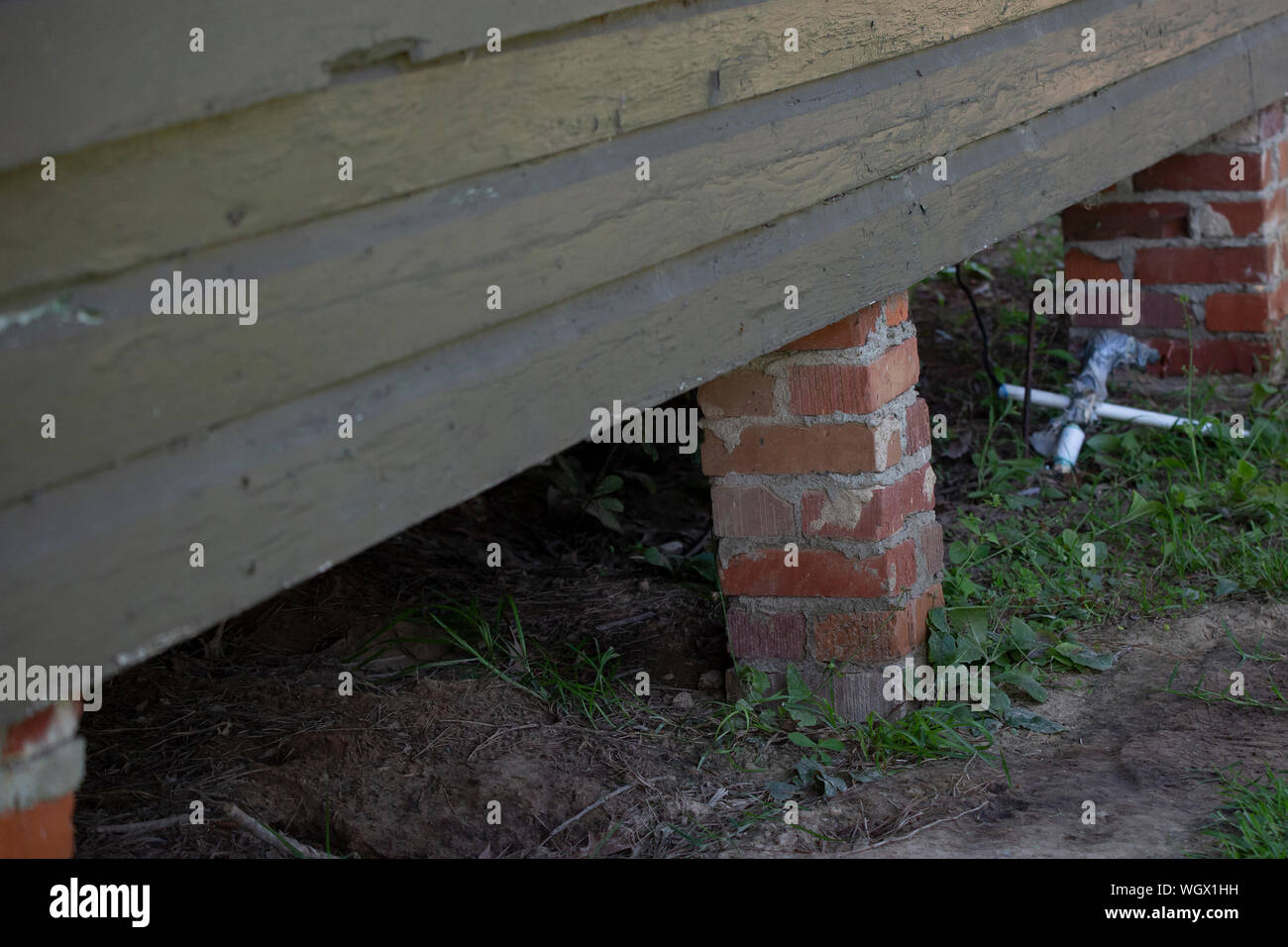 Brick columns propping up a small wooden house Stock Photo - Alamy