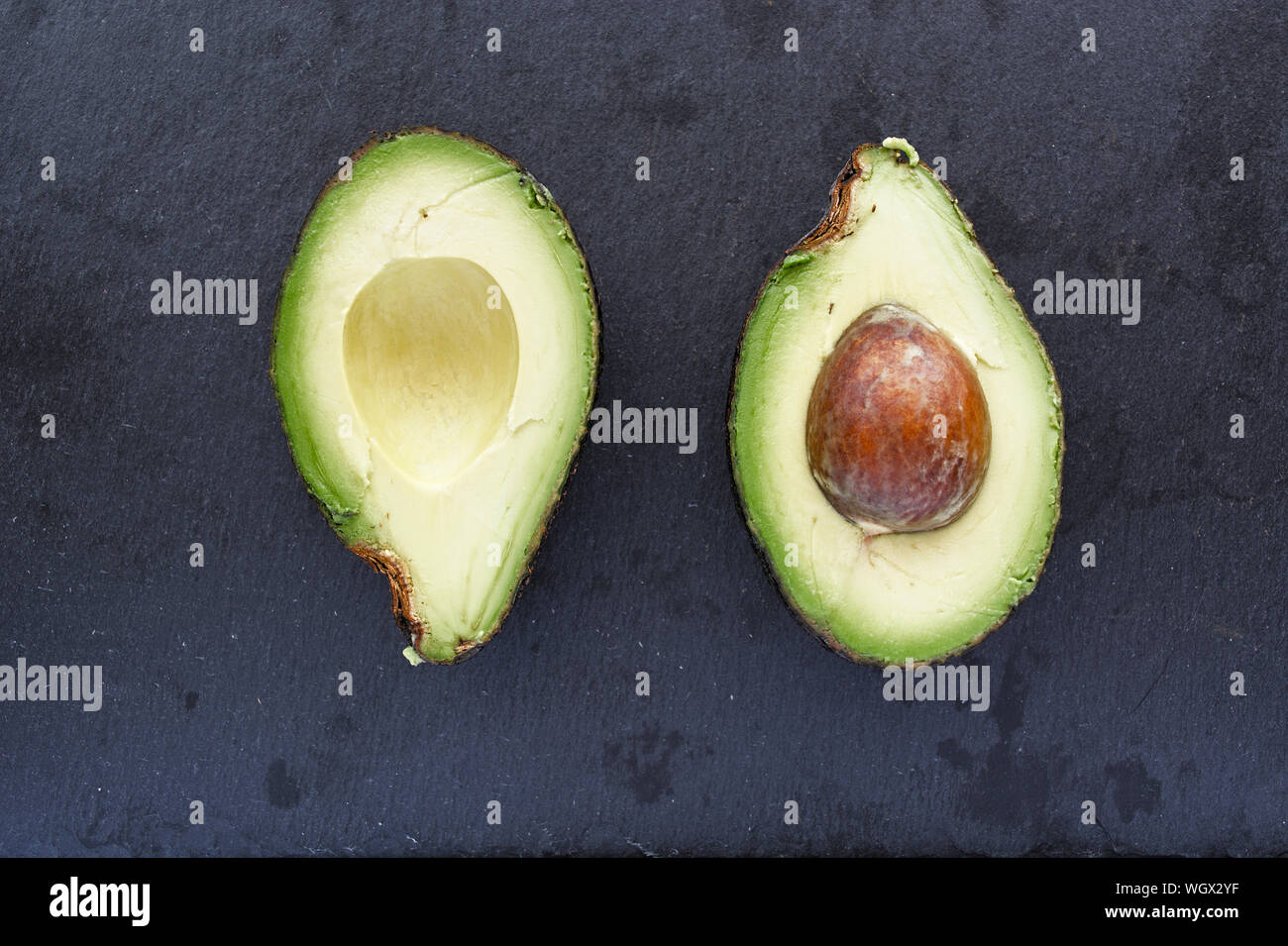 Avocado cut in half roughly Stock Photo - Alamy