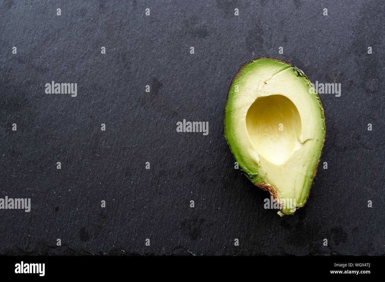Avocado cut in half roughly Stock Photo - Alamy