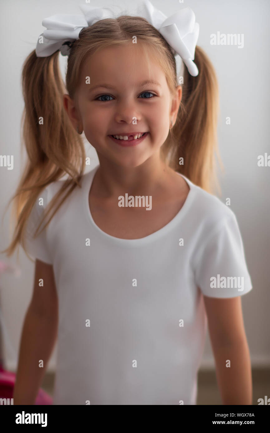 Caucasian long-haired little girl with big white bows on the head . She ...