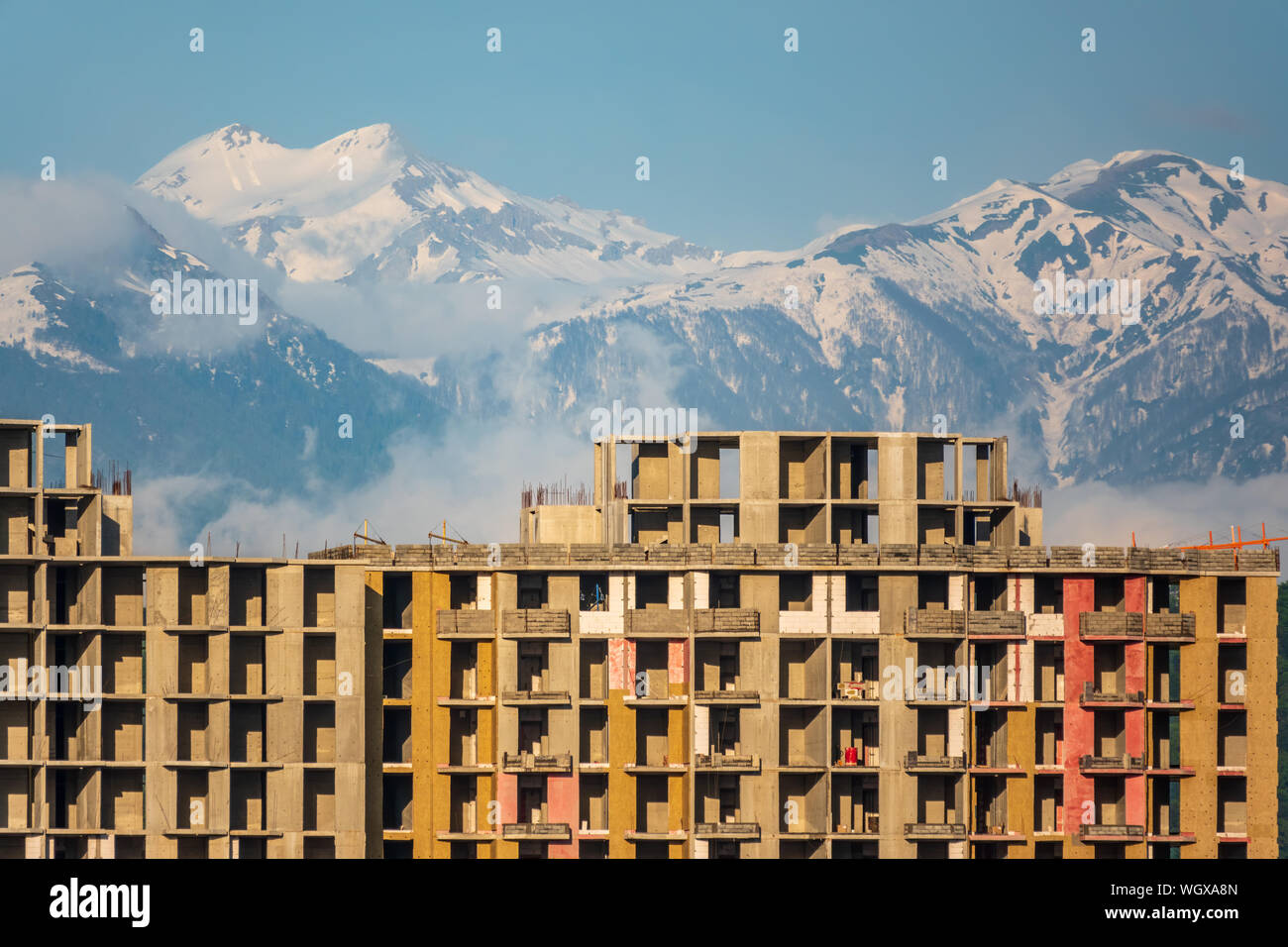 The construction of a tall house on a background of mountains with ...