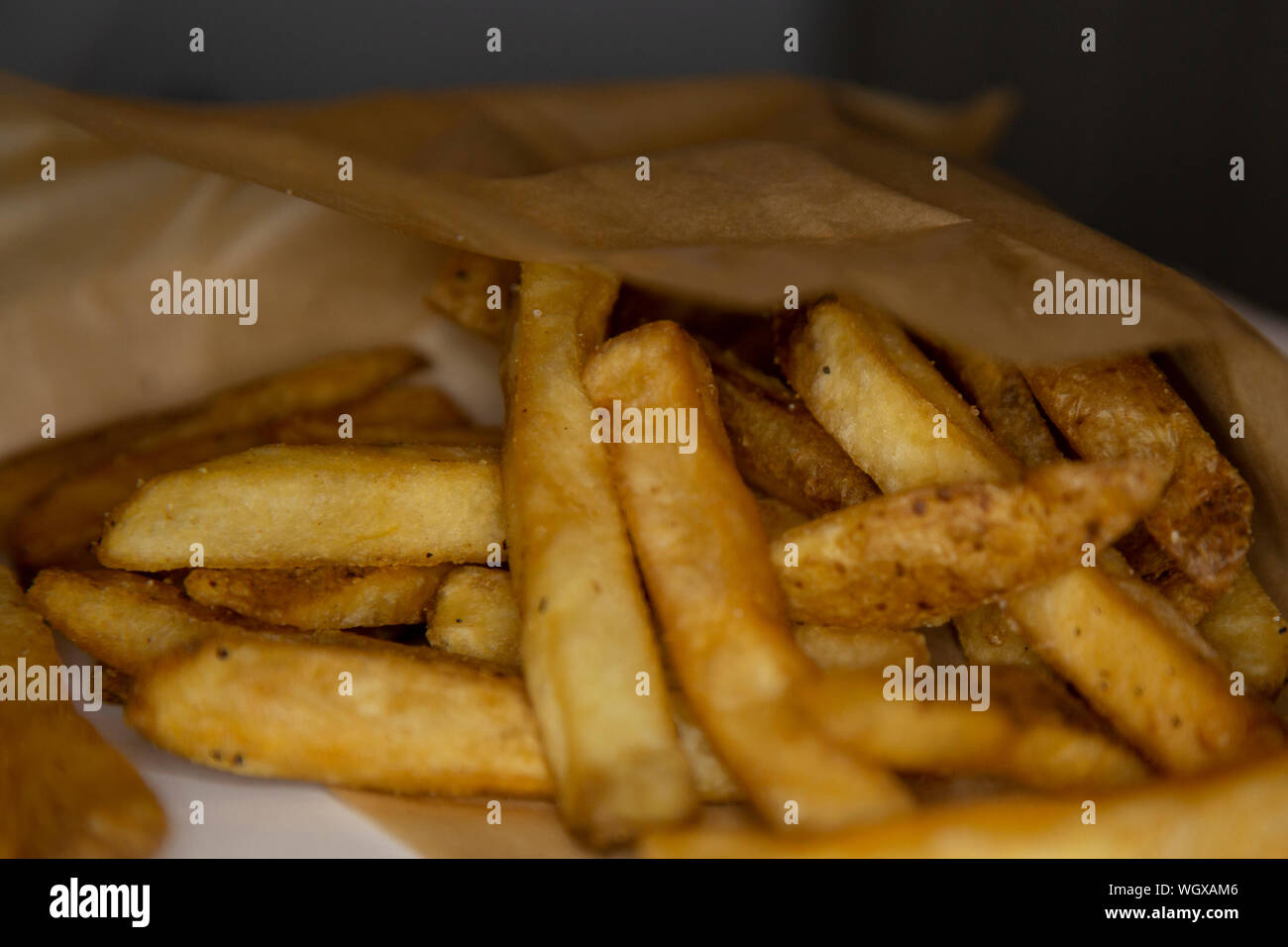 Golden fried french fries in brown paper wrapping Stock Photo - Alamy