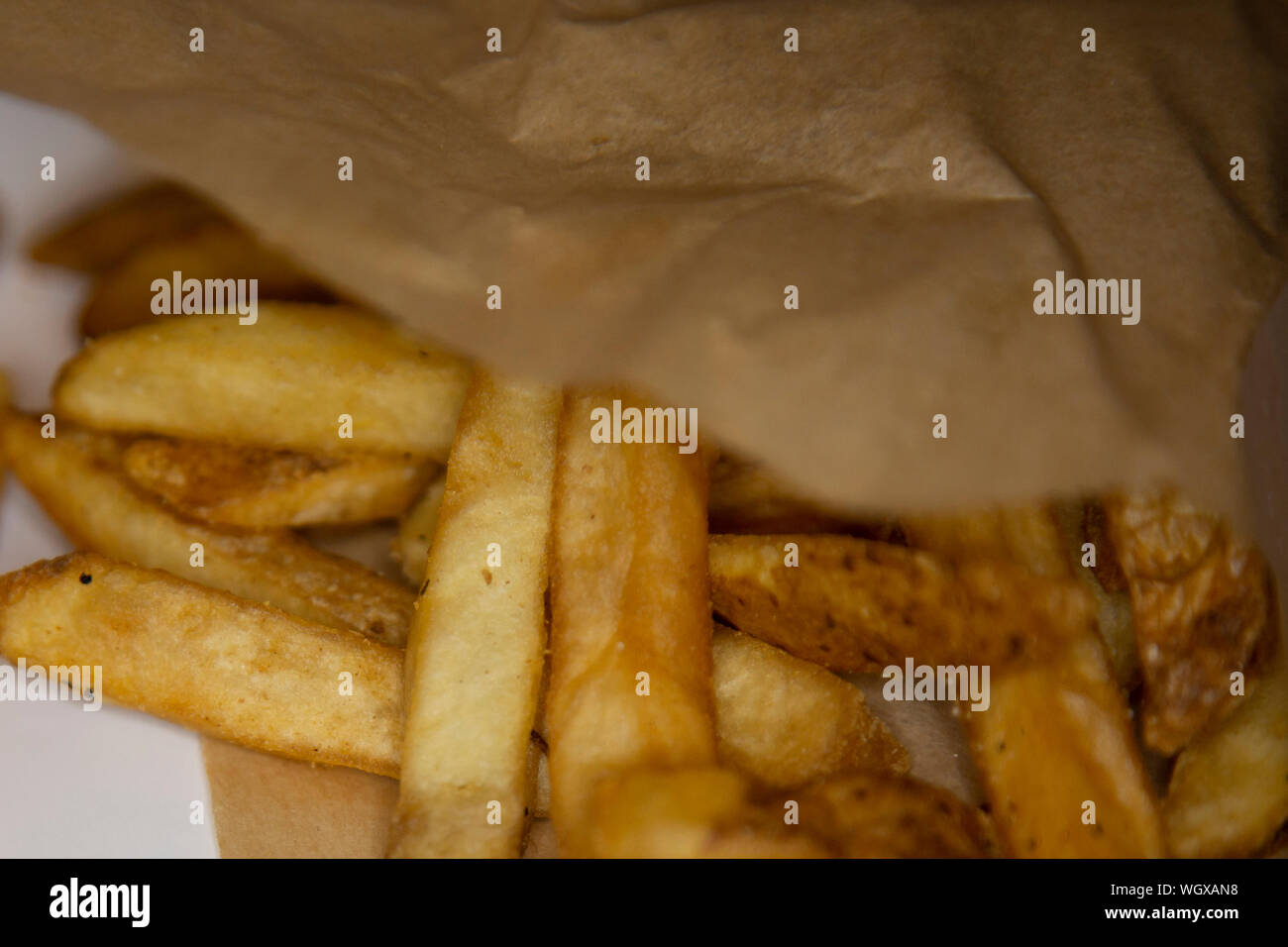 Golden fried french fries in brown paper wrapping Stock Photo - Alamy