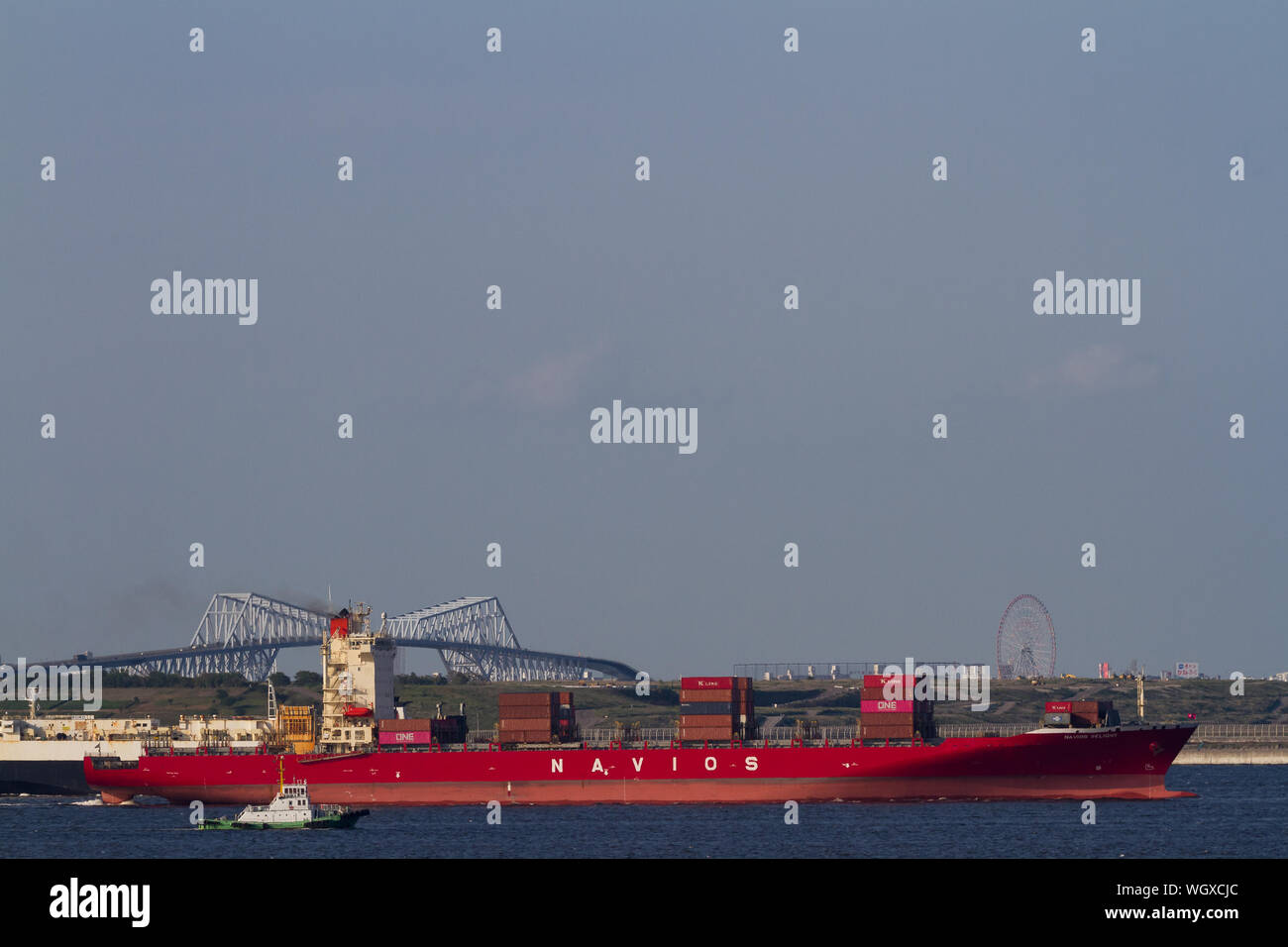A large red container ship and a tug boat in Tokyo Bay, Tokyo, Japan ...