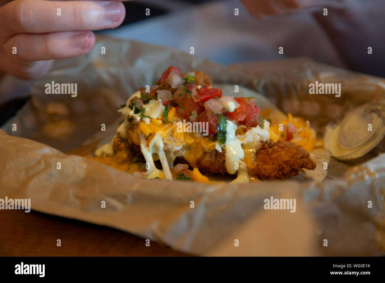 Fried chicken taco with pico de gallo, cheddar cheese, and a soft shell ...