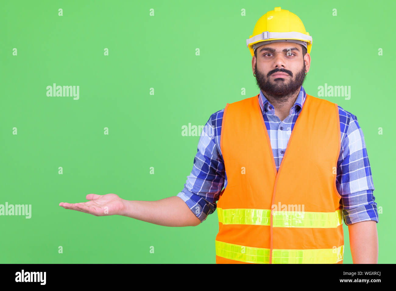 Young overweight bearded Indian man construction worker showing ...