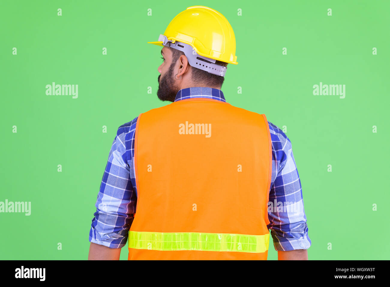 Rear view of young overweight bearded Indian man construction worker ...