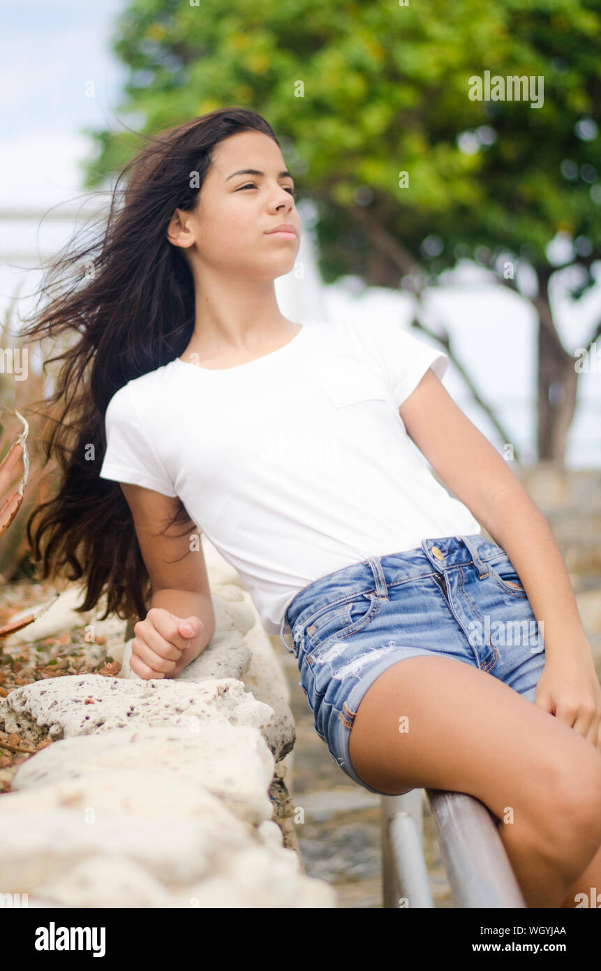 Young Woman Sitting On Railing Stock Photo - Alamy