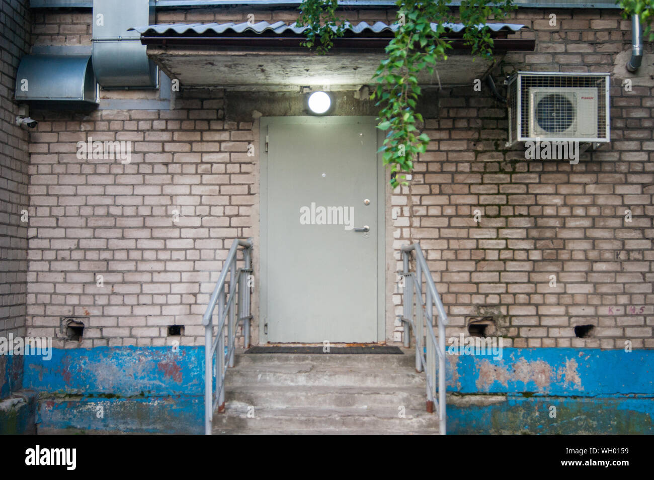 White door on a brick wall in the utility room. Porch, fan. Entrance ...