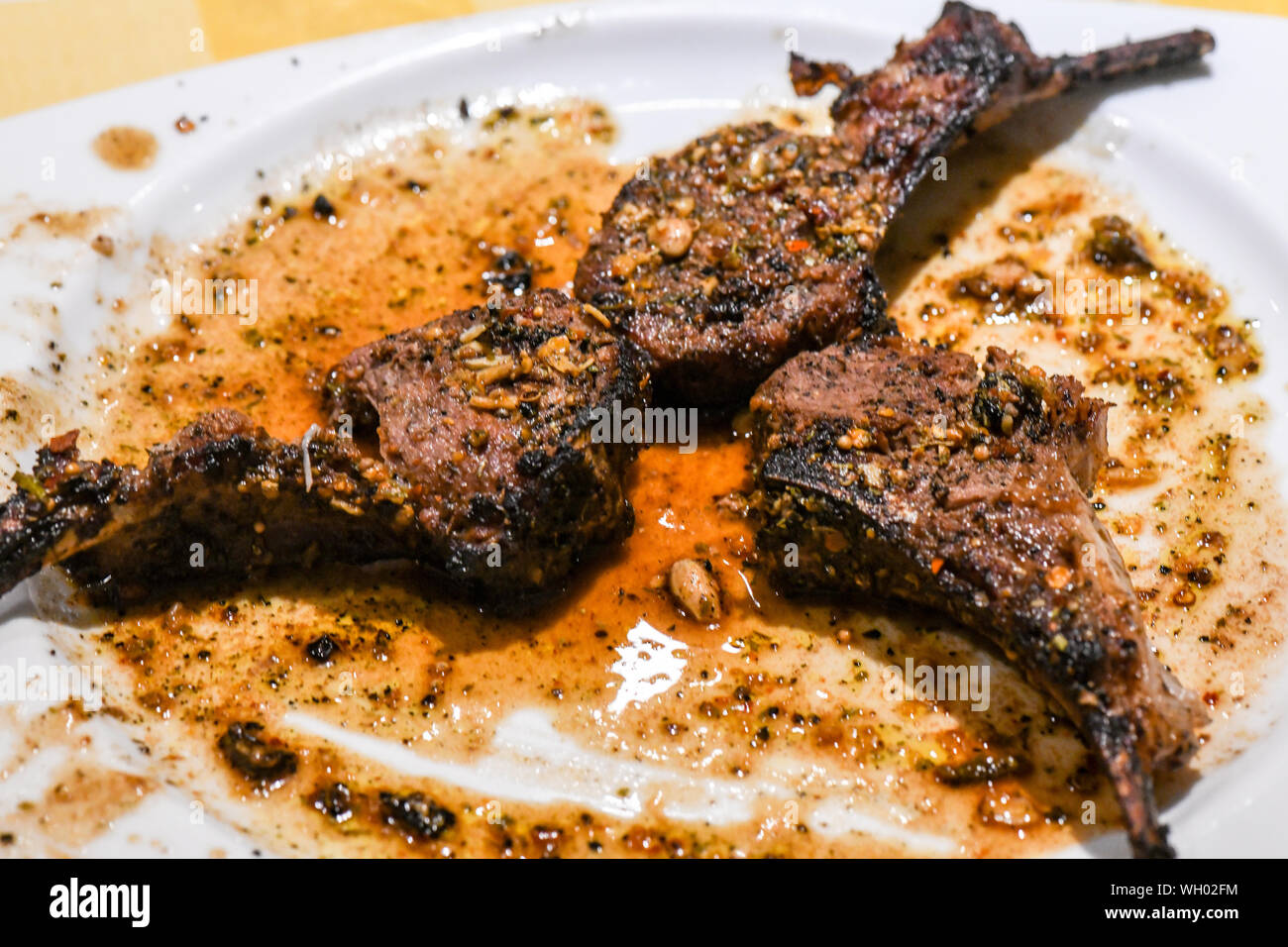 Well done Rib eye steak in greasy white plate. The steak with tender ...