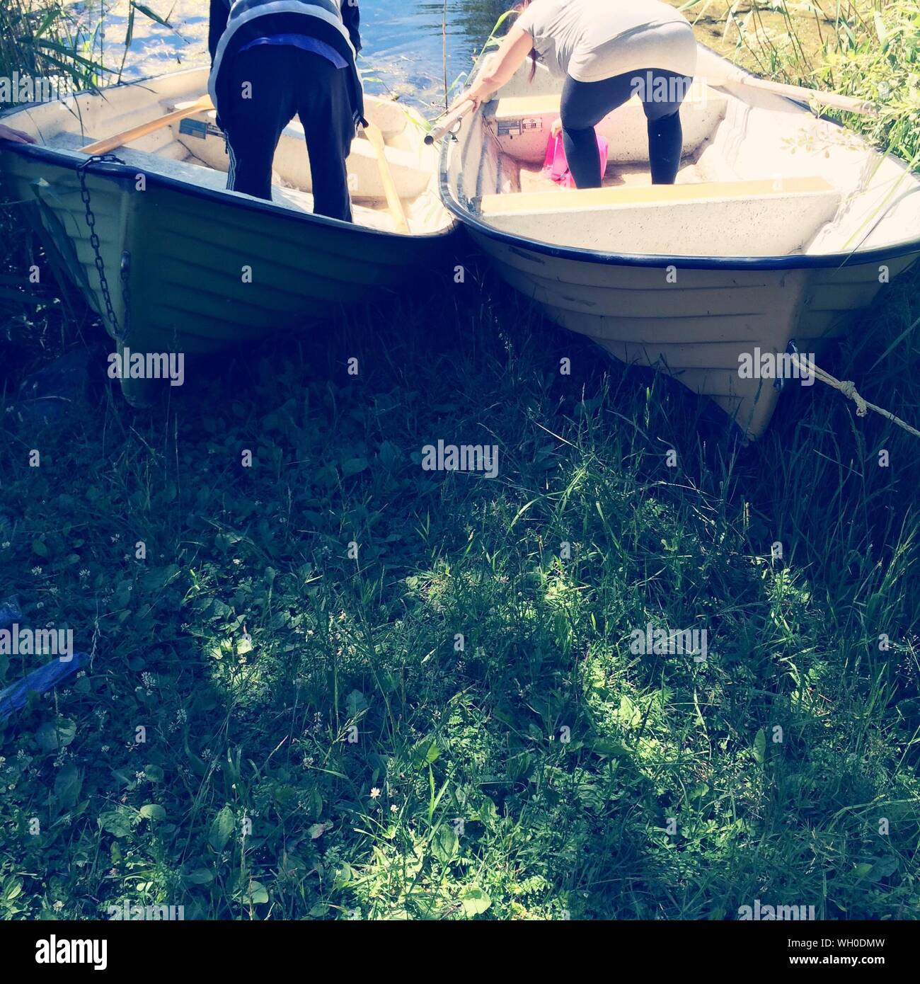 Rear View Of People Standing In Boats On Lakeshore Stock Photo - Alamy