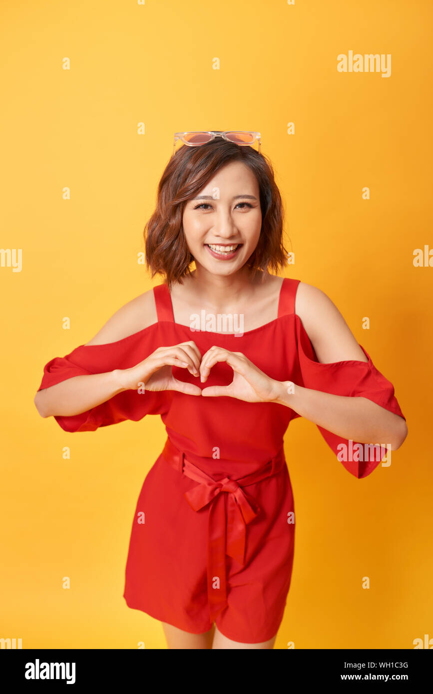 Smiling young girl showing heart with two hands, love sign. Isolated ...