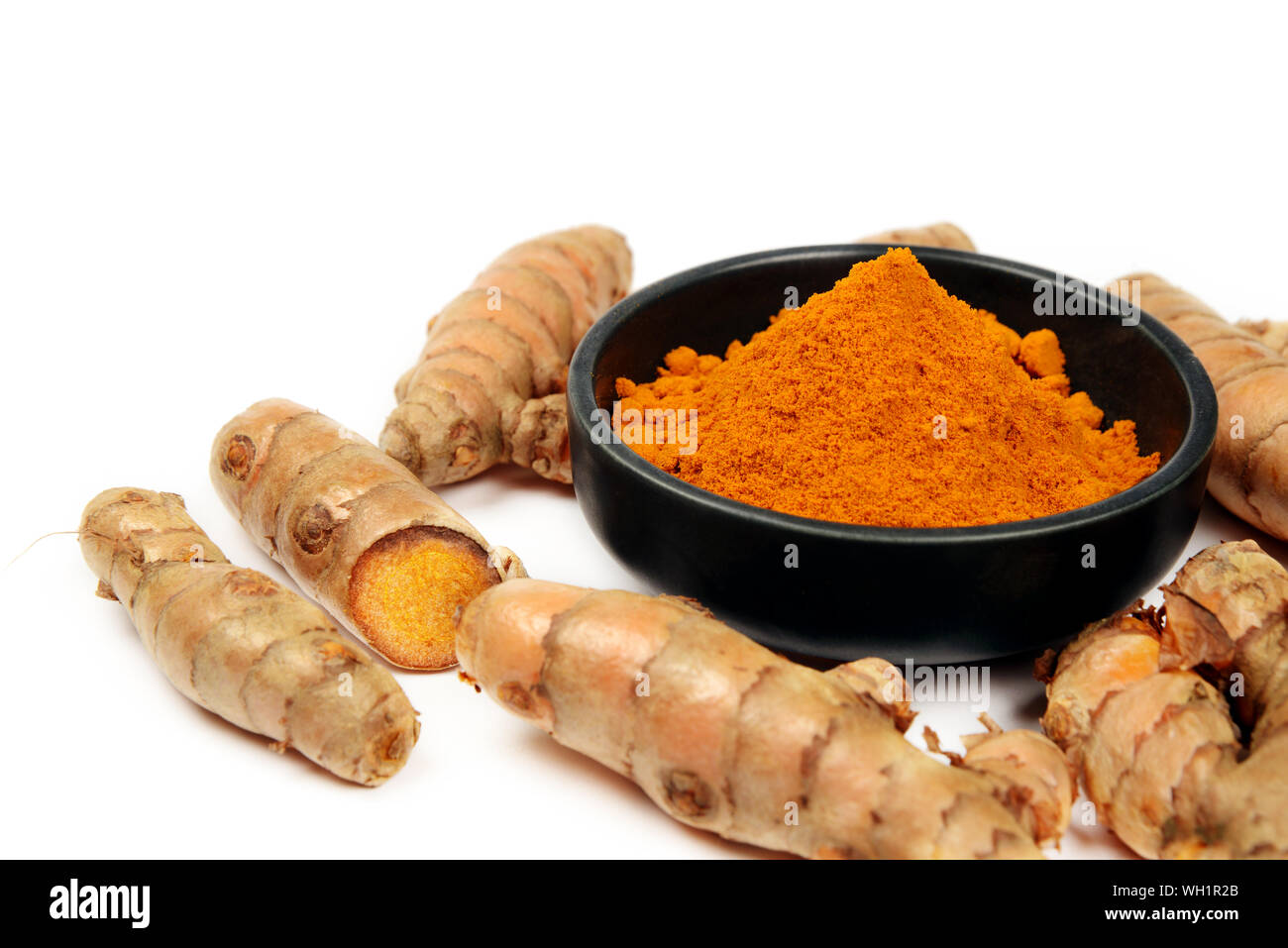 Fresh turmeric powder in a bowl and turmeric root, Indian spices an ...