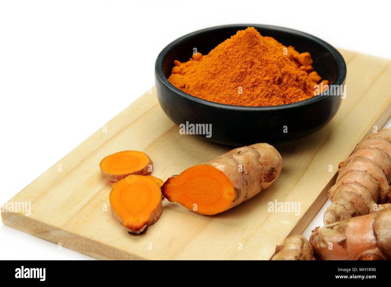 Fresh turmeric powder in a bowl and turmeric root, Indian spices an ...