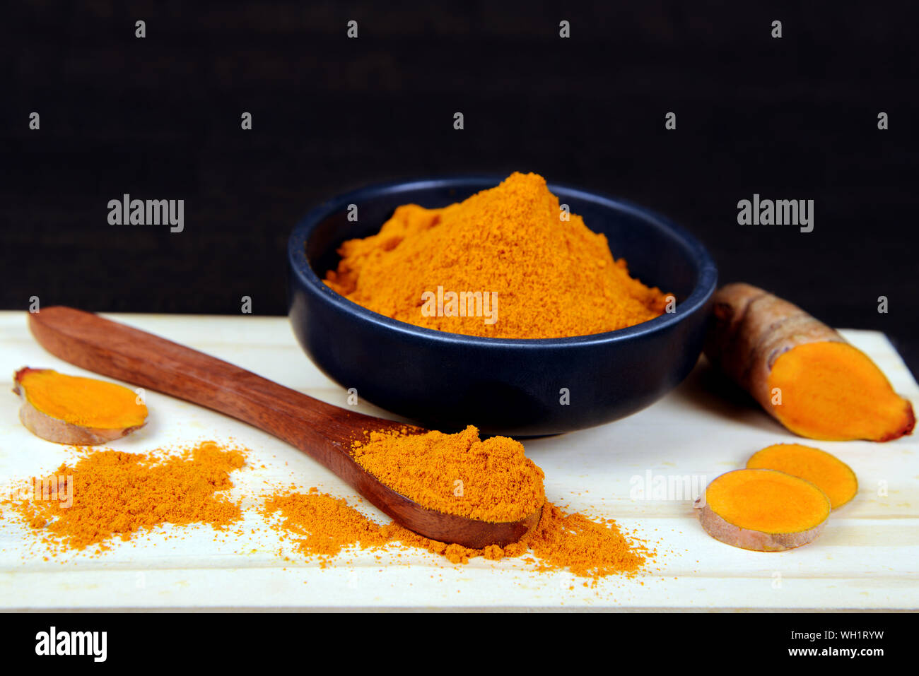 Fresh turmeric powder in a bowl and turmeric root, Indian spices an ...