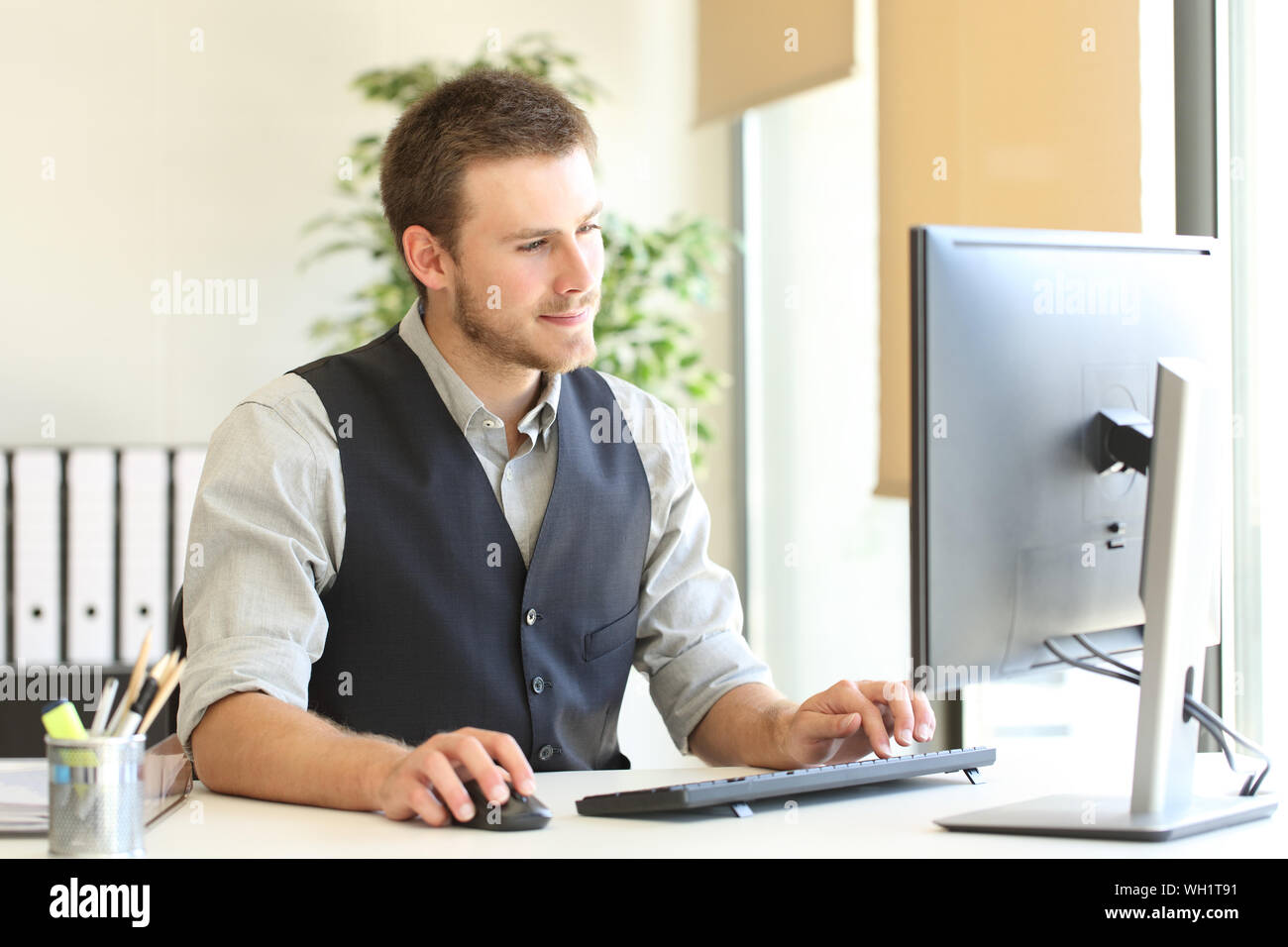 Serious executive browsing desktop computer content sitting at office ...