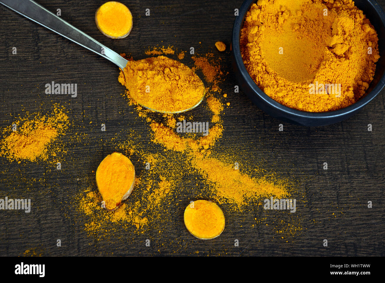 Fresh turmeric powder in a bowl and turmeric root, Indian spices an ...