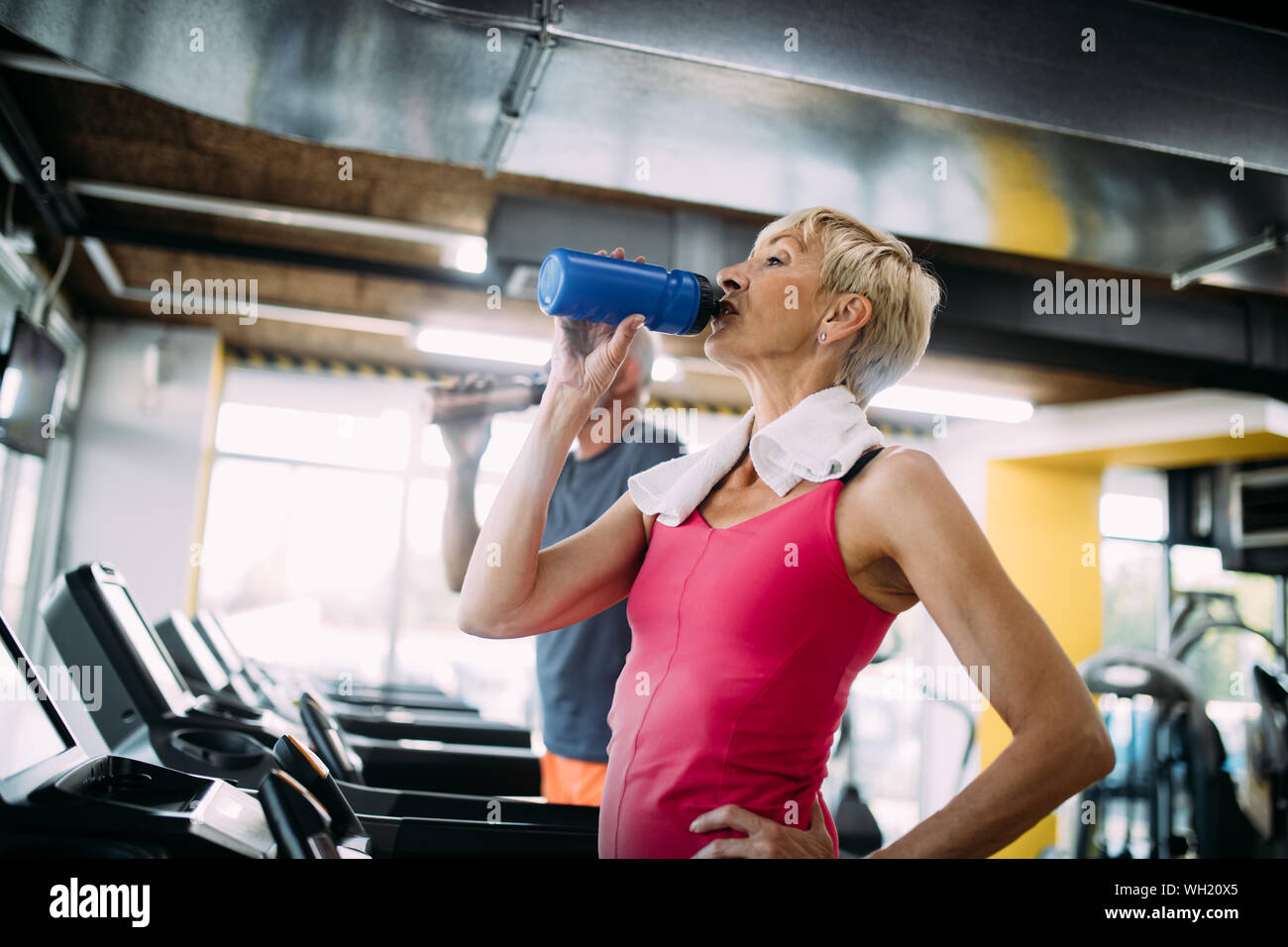 Happy senior people running together on treadmills in gym Stock Photo ...