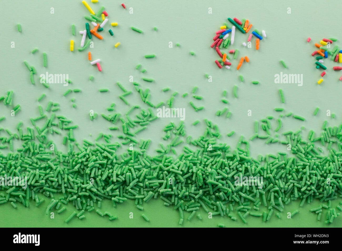 Green sprinkles on two tone green background with multi coloured ...