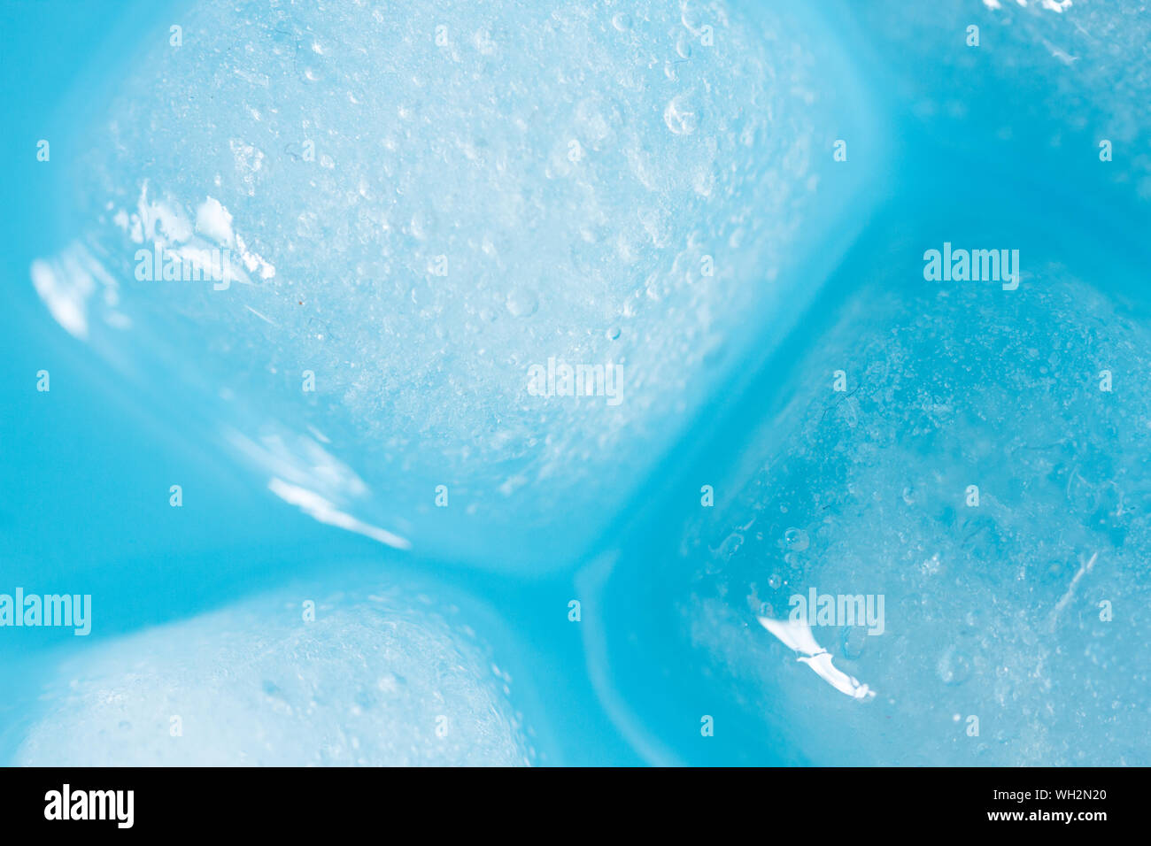 Melting ice cubes background on blue background Stock Photo - Alamy