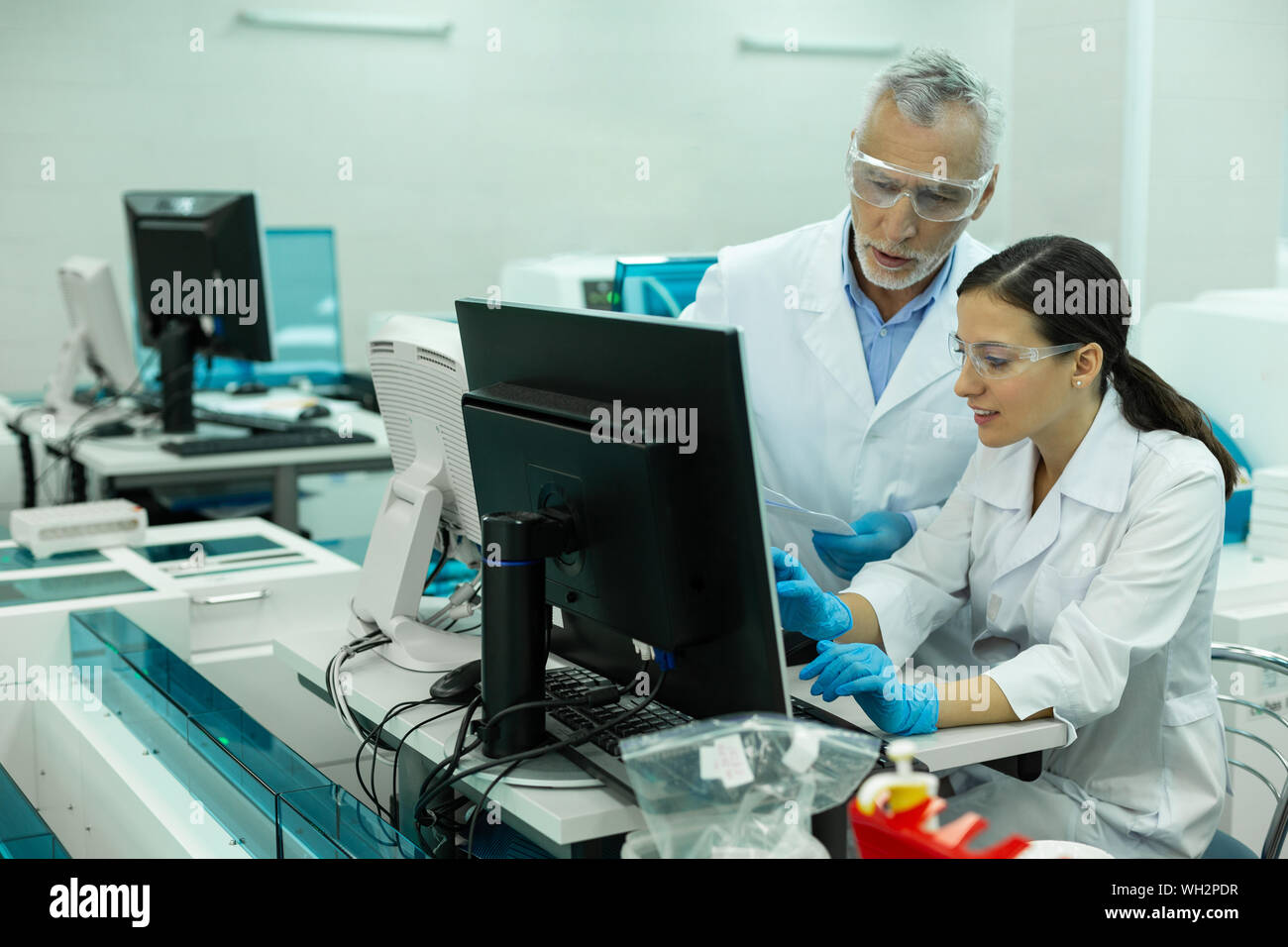 Positive delighted colleagues working at their project Stock Photo - Alamy
