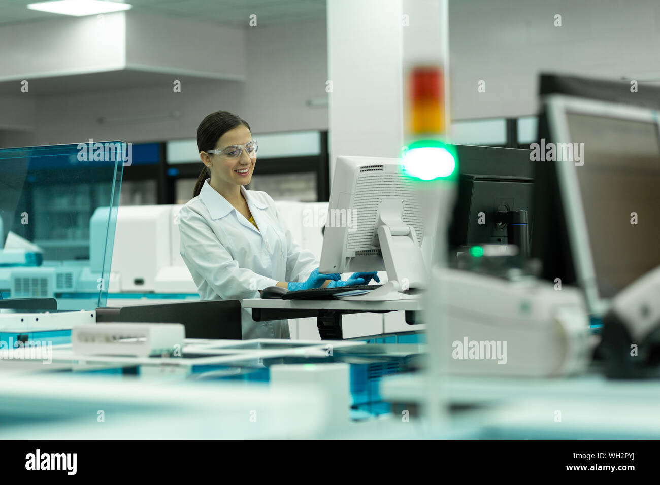 Joyful young researcher looking at screen of computer Stock Photo - Alamy