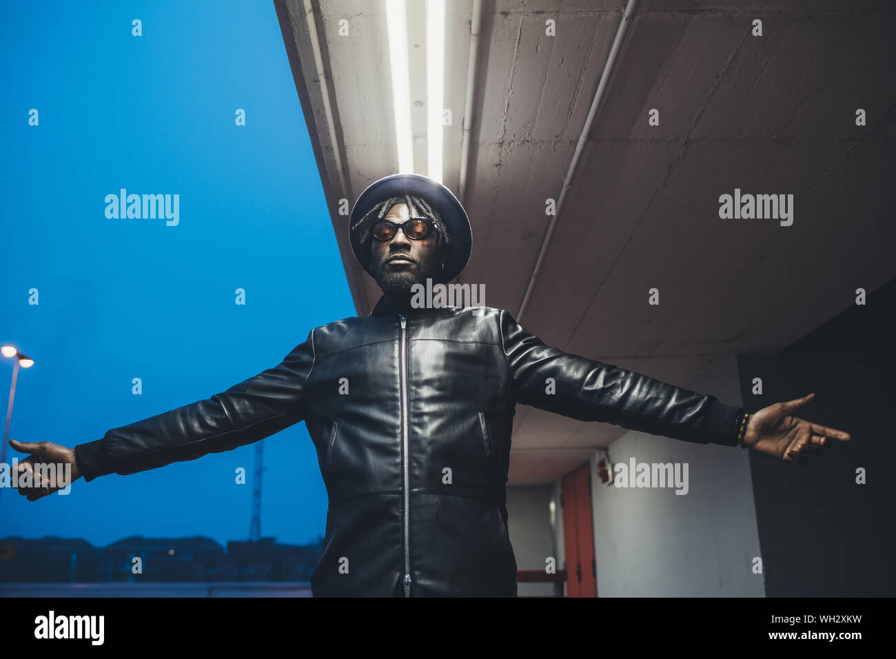 portrait of young black man standing outdoor with open arms looking the ...