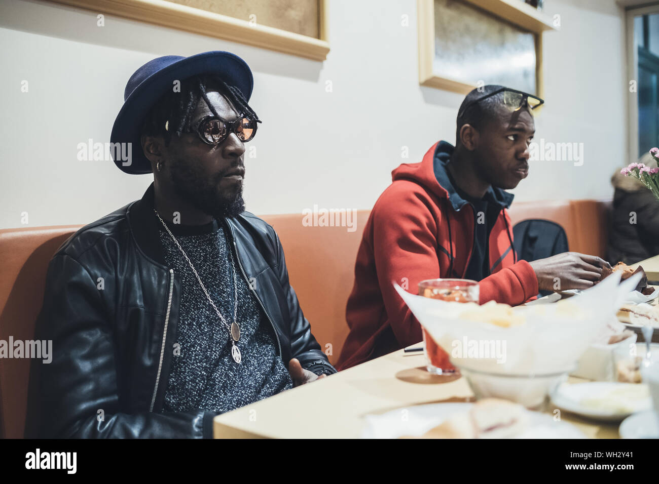 young black men indoor sitting bar having conversation - meal ...