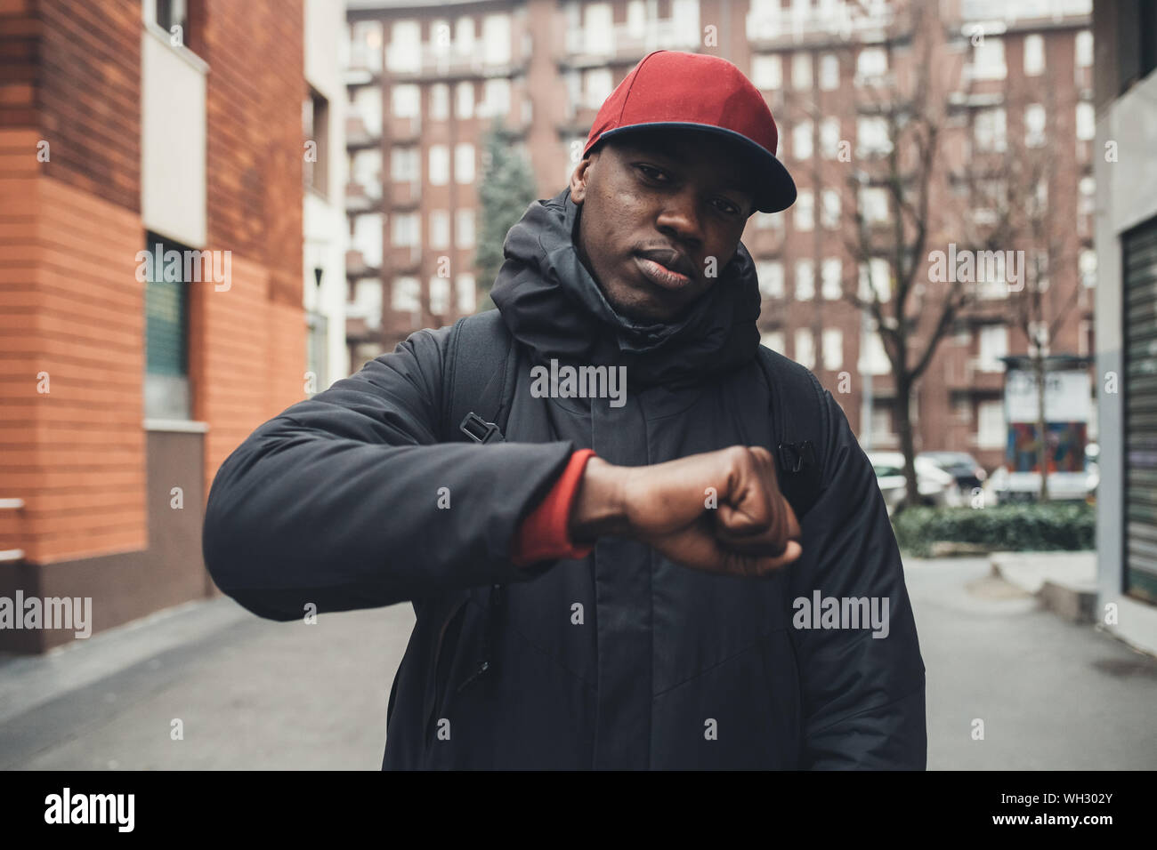 portrait of young african man standing in the street showing hands ...