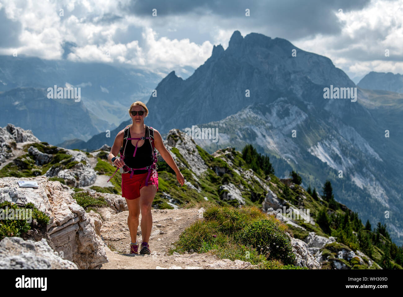 A woman hikes on a ridge trail at high altitude on Dent du Villard near ...