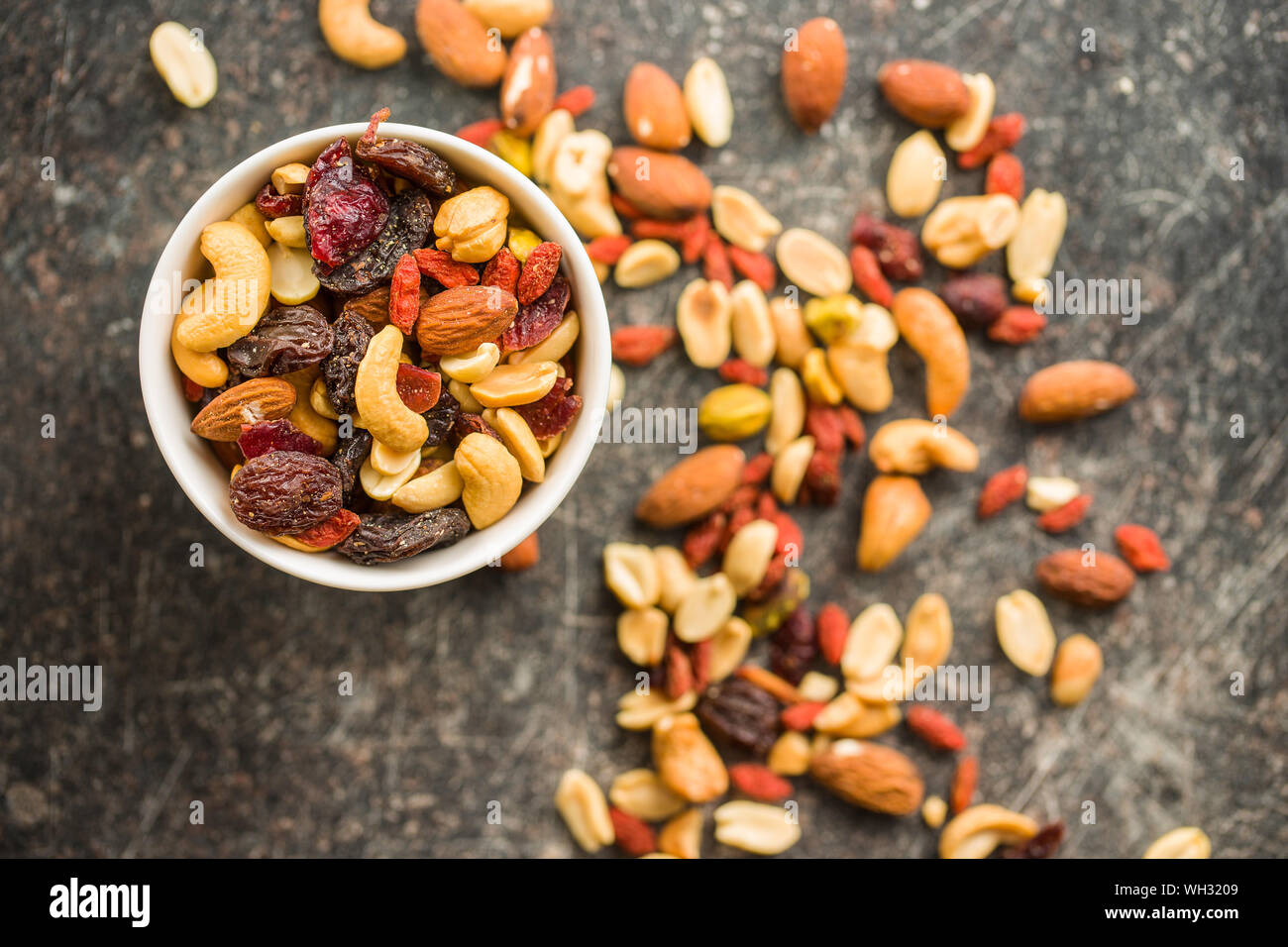 Mix of various nuts and raisins in bowl. Top view Stock Photo - Alamy