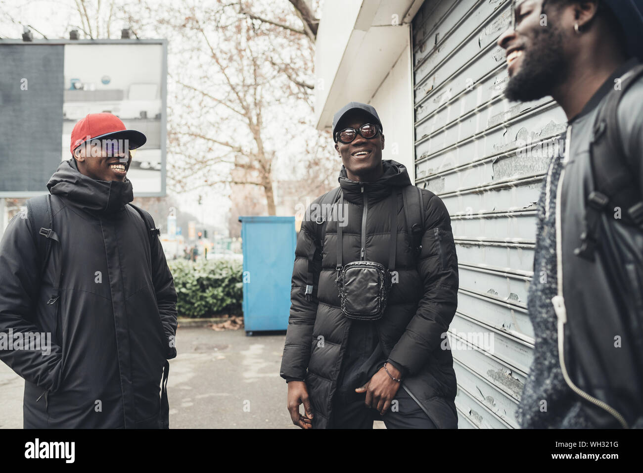 three african men standing in the street and having conversation ...