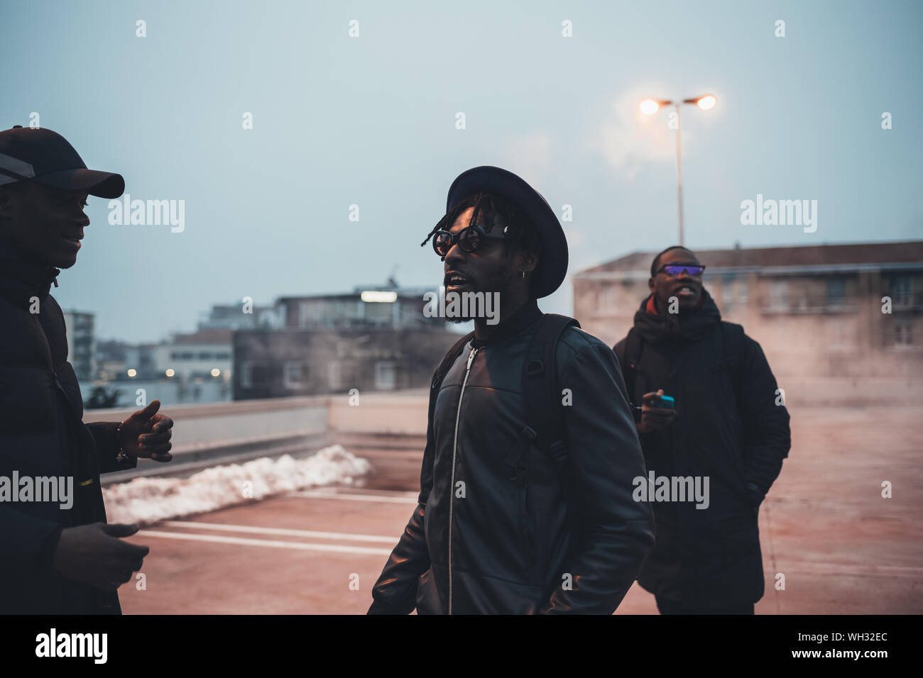 three young african men walking in the street and speaking ...