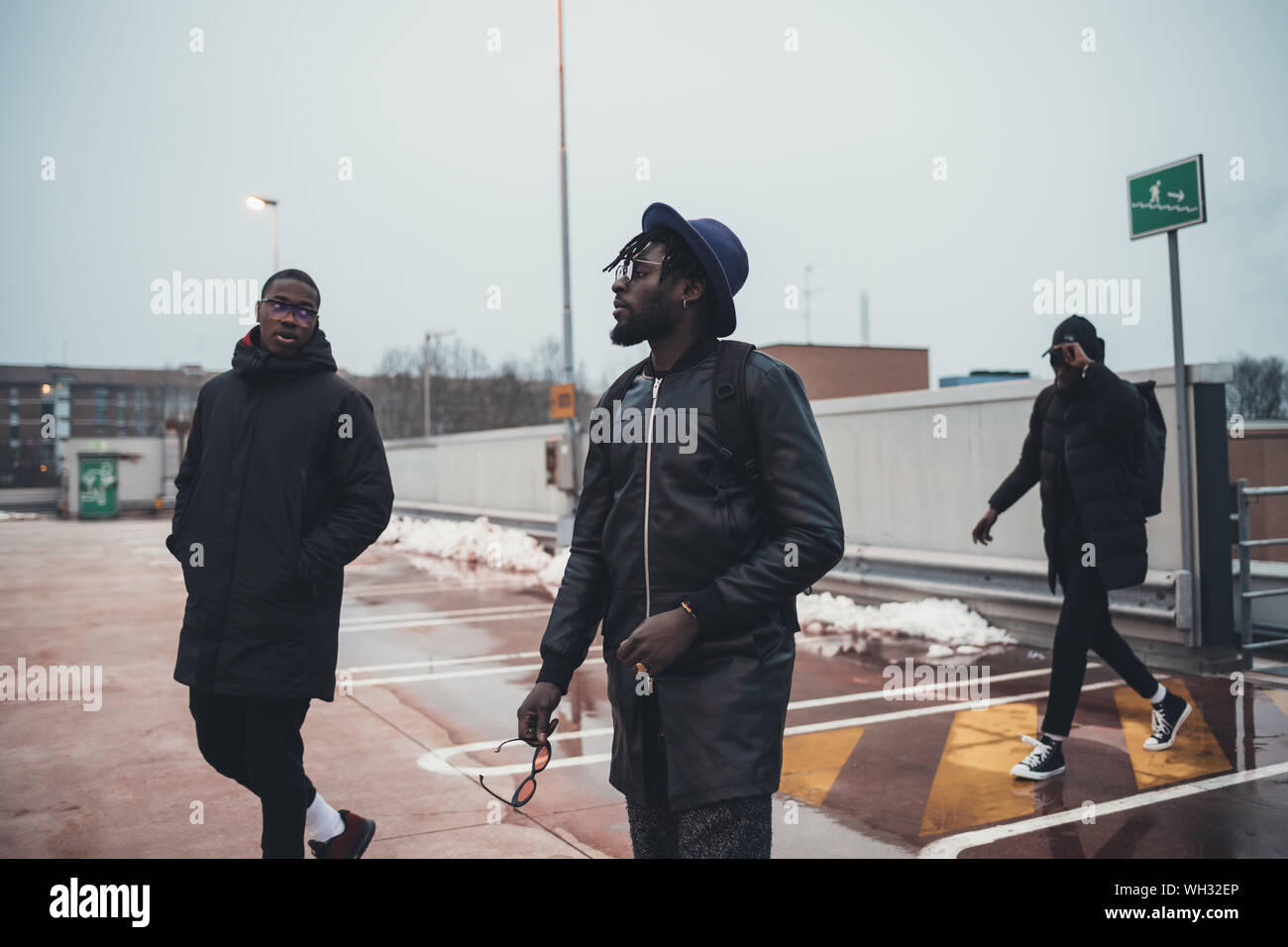 three young african men walking in the street and speaking ...