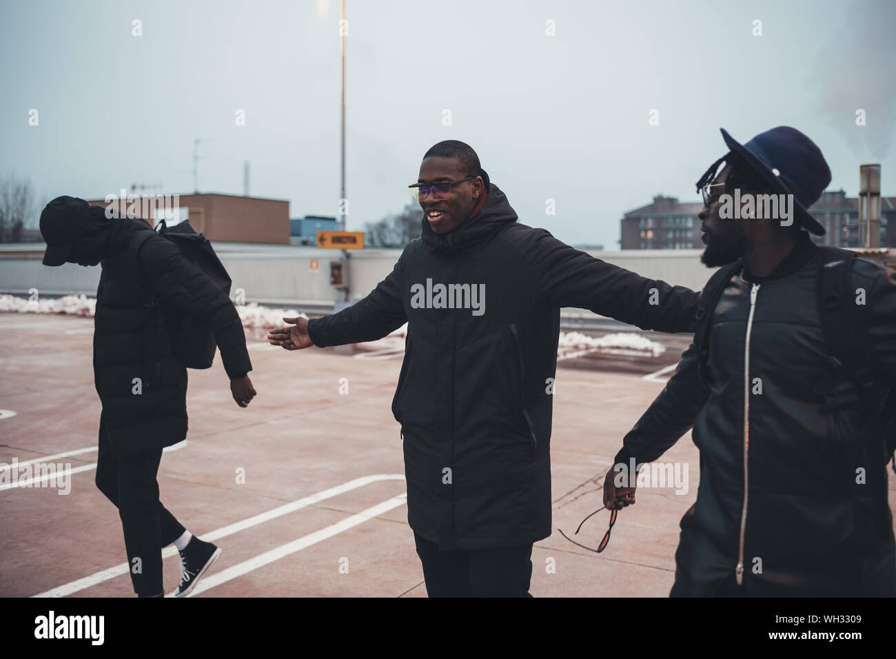 three young african men walking in the street and speaking ...