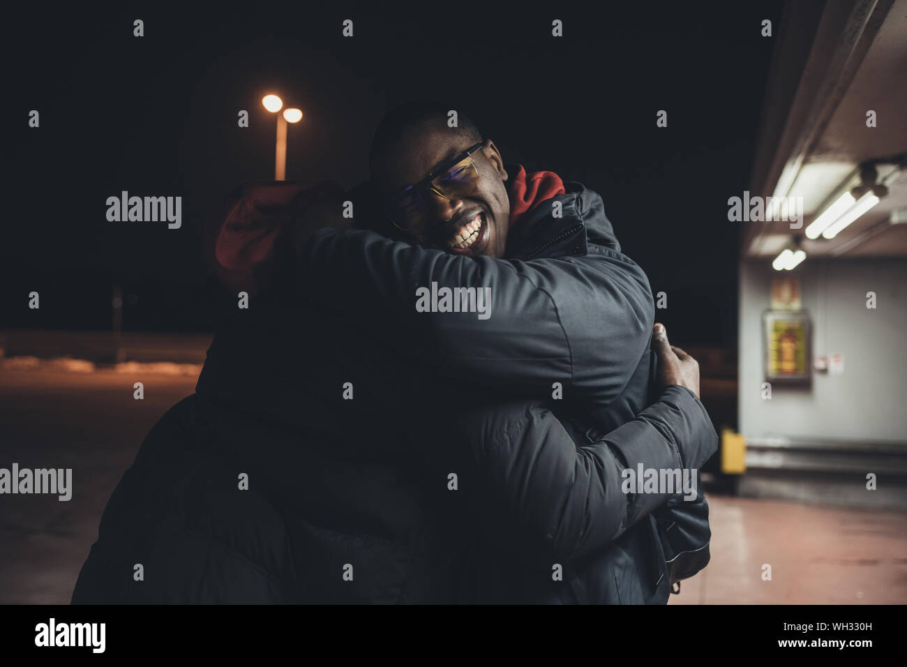 two young men outdoors parking lot greetings hugging - gestures, swag ...