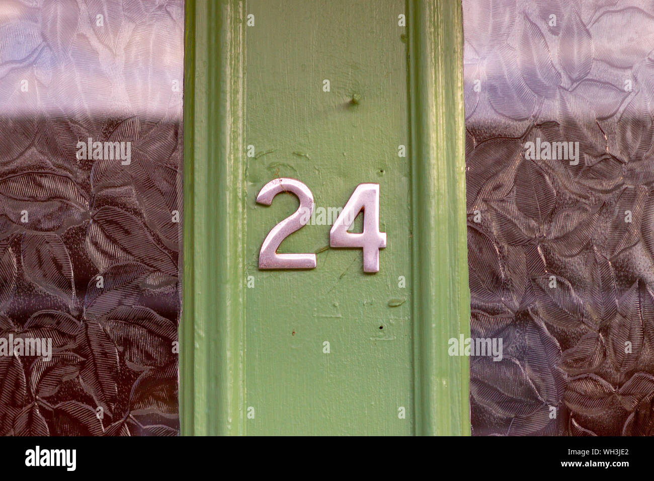 House number 24 seen on a green door with glass panels Stock Photo - Alamy